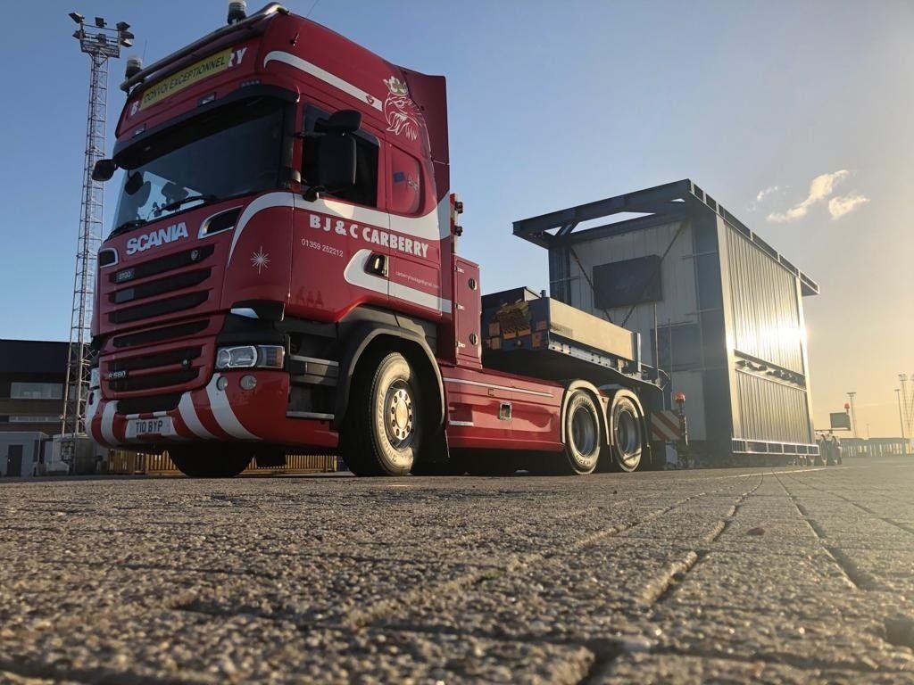 Wafer bed low loader loaded with asphalt hot box.