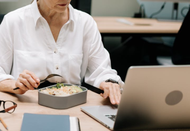 Employees Eating At Desk